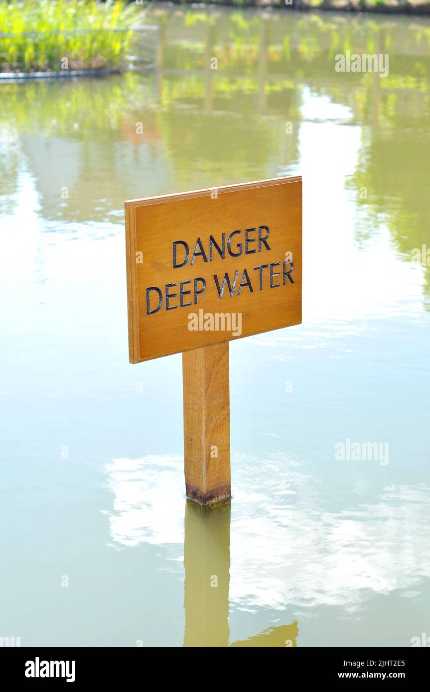 Wooden DANGER DEEP WATER sign in middle of lake Stock Photo - Alamy