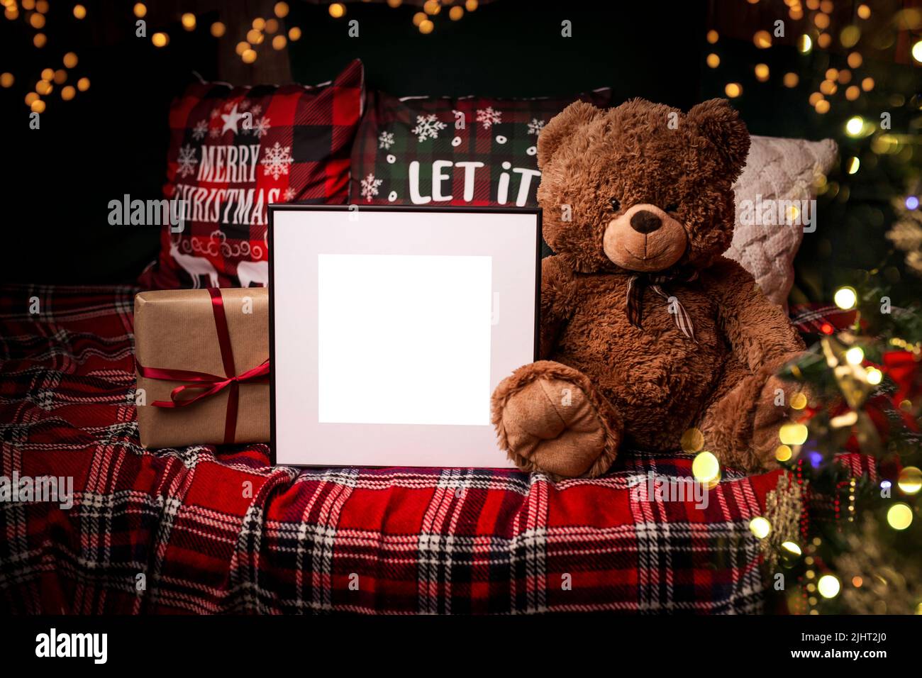 A christmas presents including a brownish teddy bear on the couch Stock ...