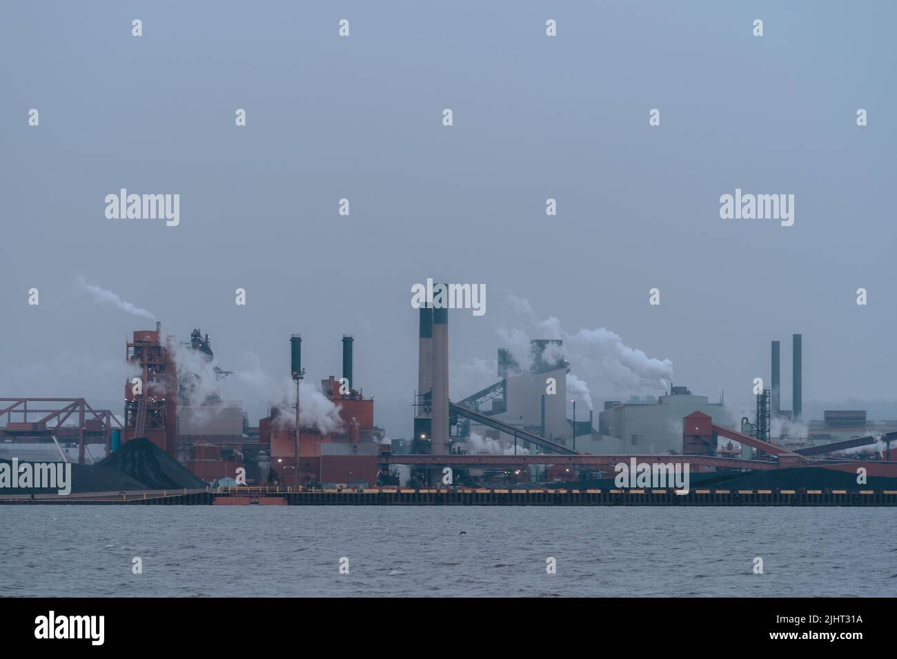 An aerial view of industrial area with chemical smoking chimneys near ...