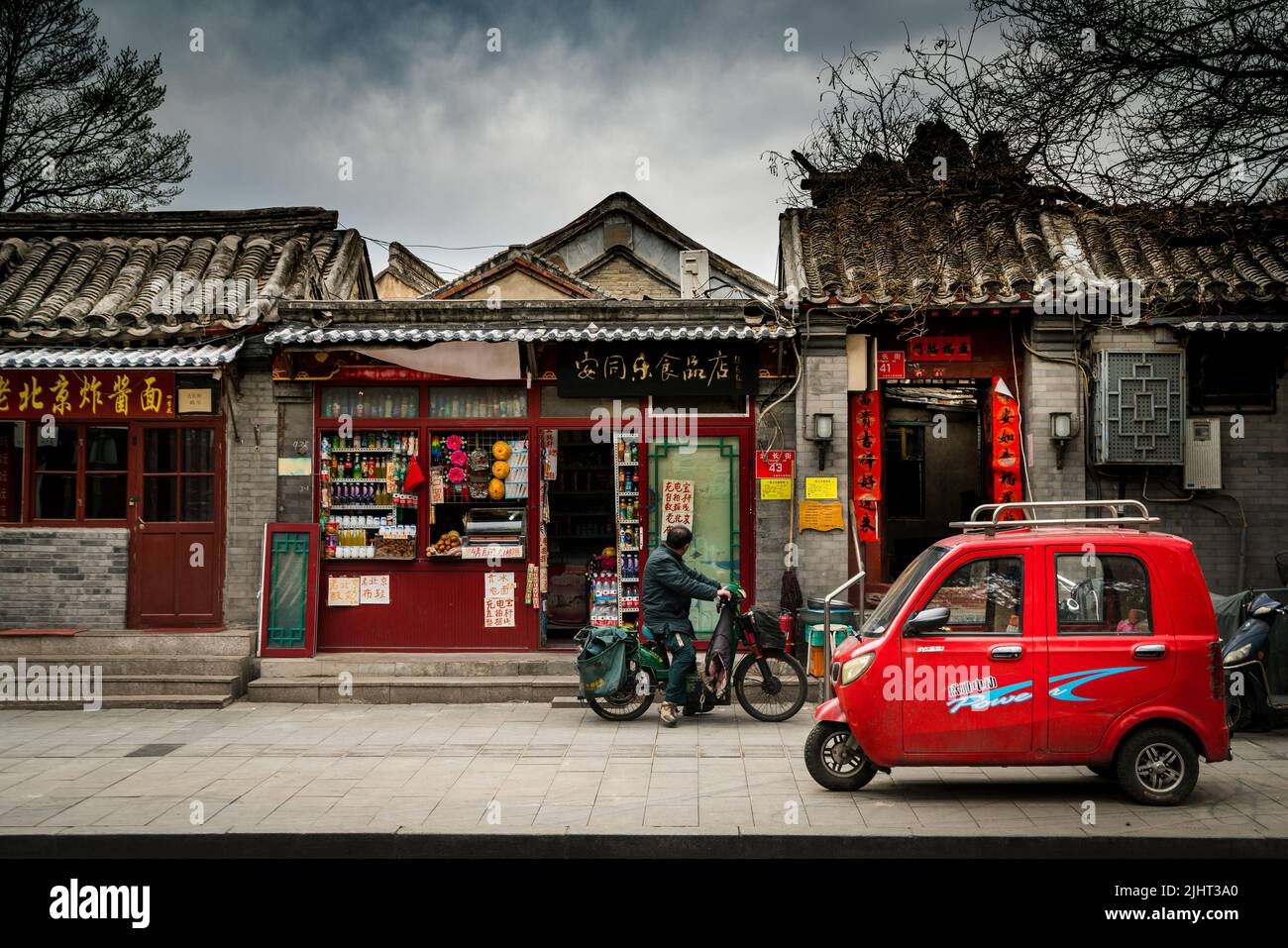 A Red Electric Car in traditional Beijing street in China street scene ...