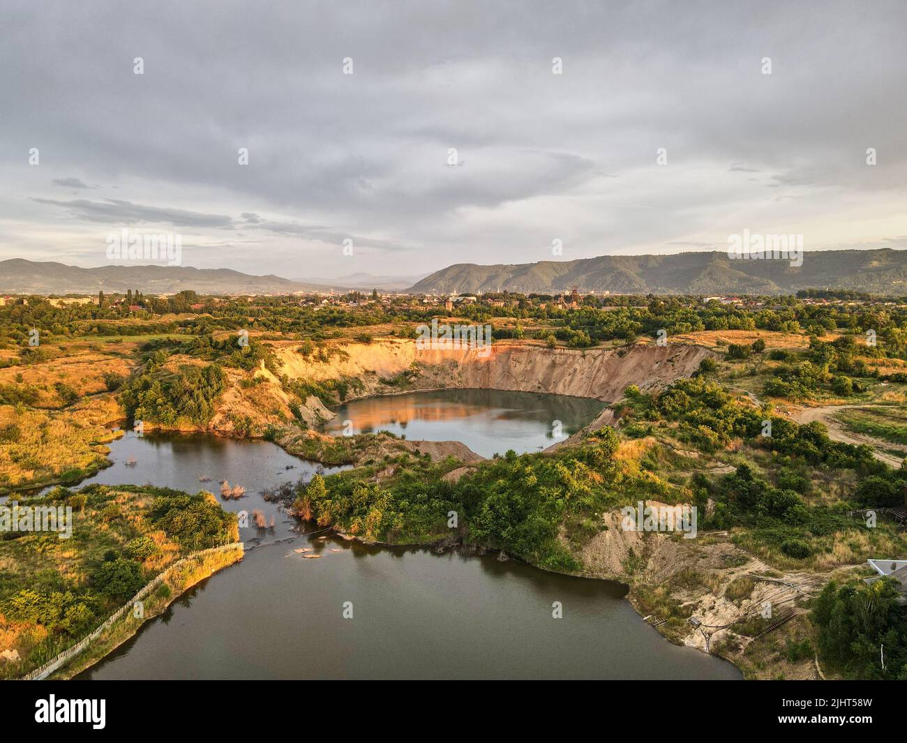 An aerial view of two lakes in the crater surrounded by greenery and ...