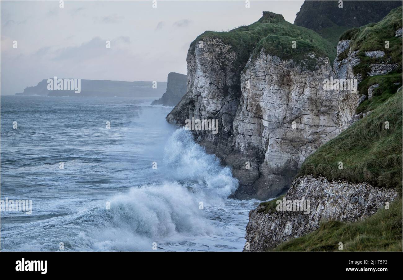 A breathtaking view of stormy sea waves crashing in to the rocky cliff ...