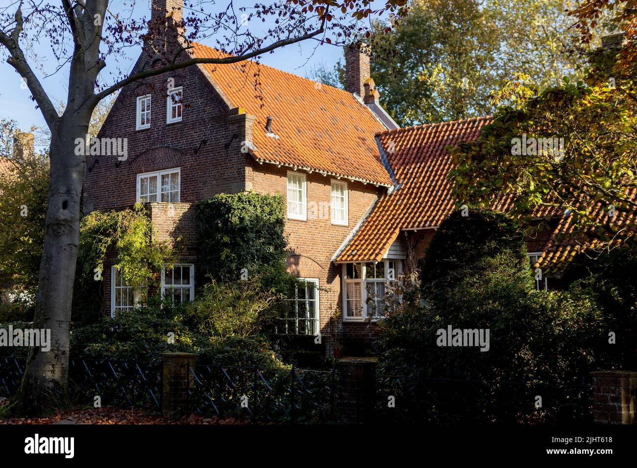 Large Dutch brick exterior facade of stately home surrounded by autumn ...