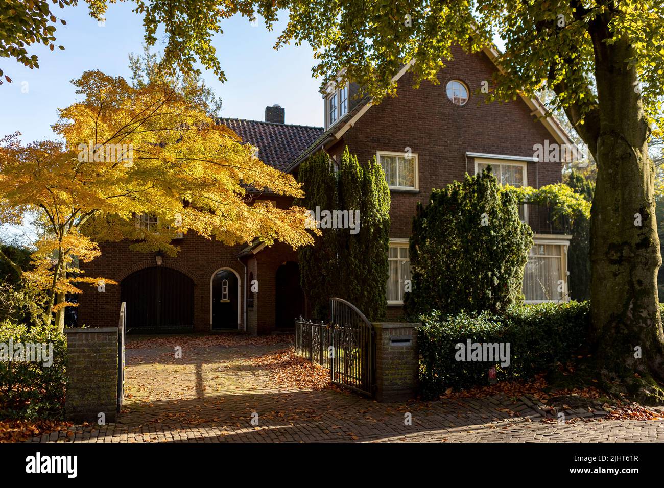 Large Dutch brick exterior facade of stately home surrounded by autumn ...