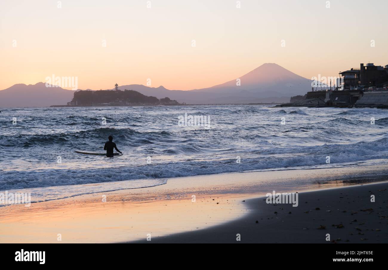 Sunset colors the beach at Kamakura. Mt Fuji and the island of Enoshima ...