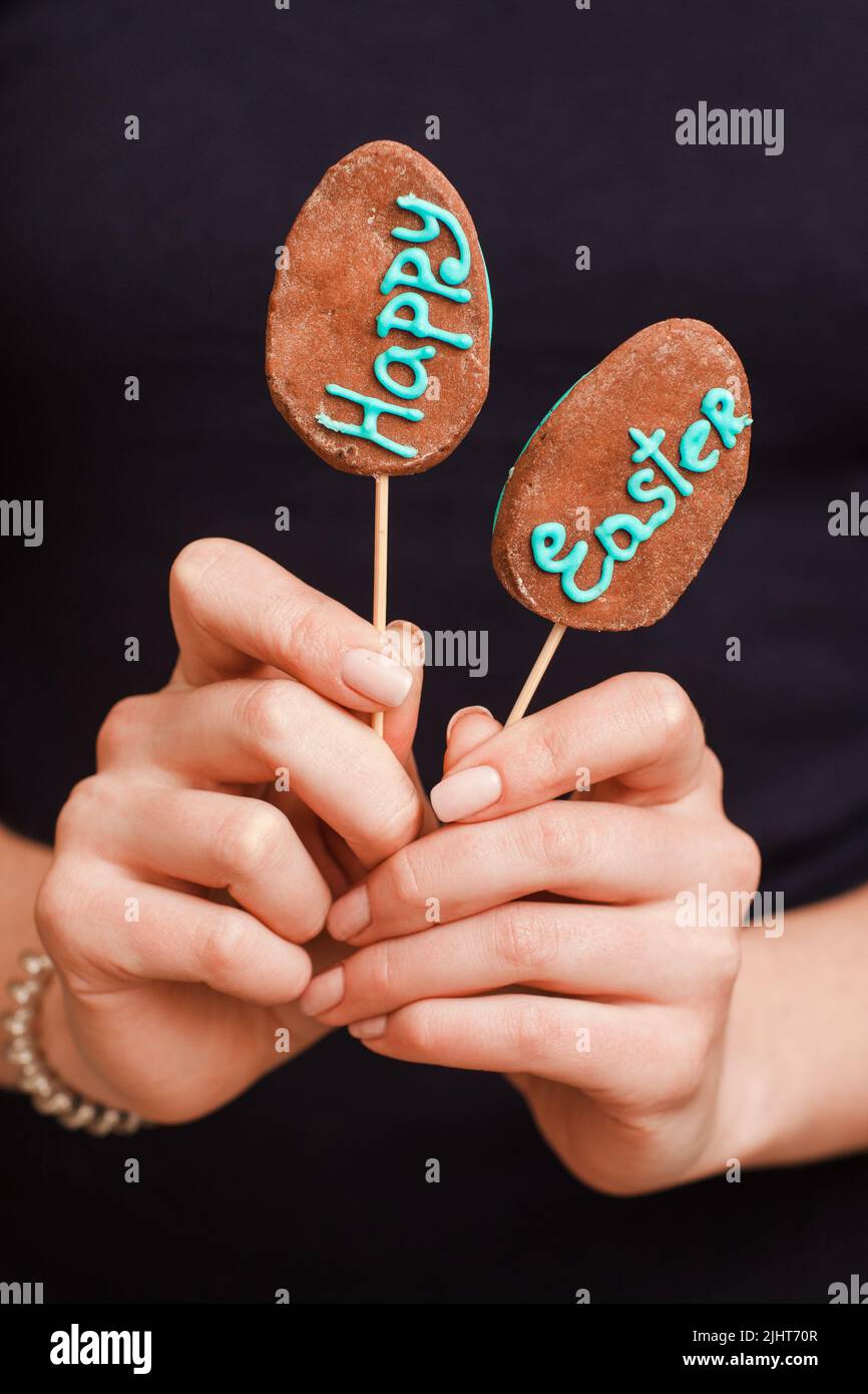 Easter decoration. Hands holding easter cookies Stock Photo - Alamy