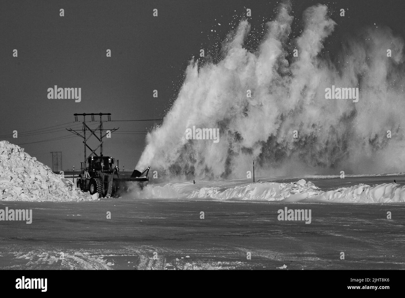 A grayscale of a Tractor clearing the snow Stock Photo - Alamy