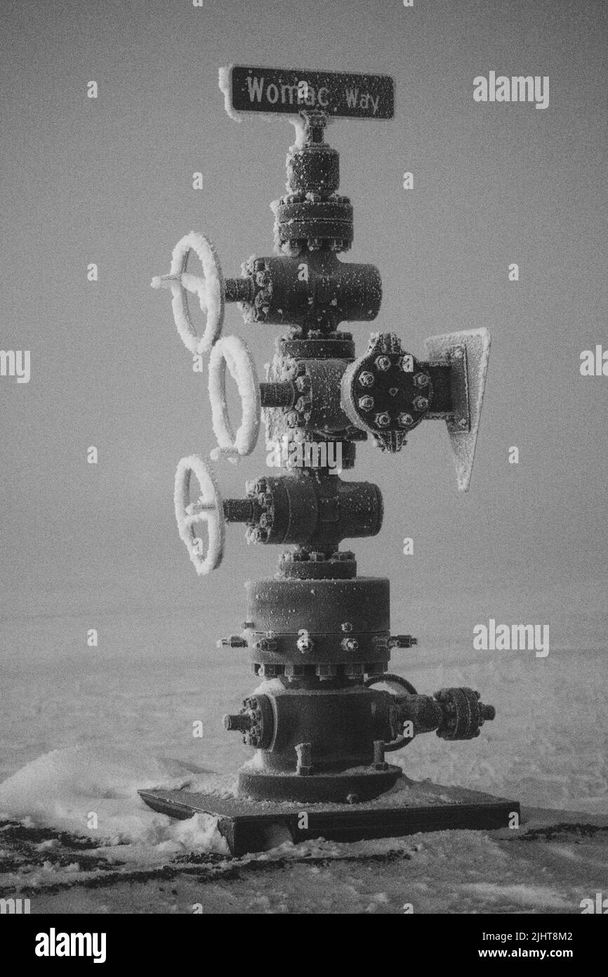 A vertical shot of a frozen Wellhead in a snowy field Stock Photo - Alamy