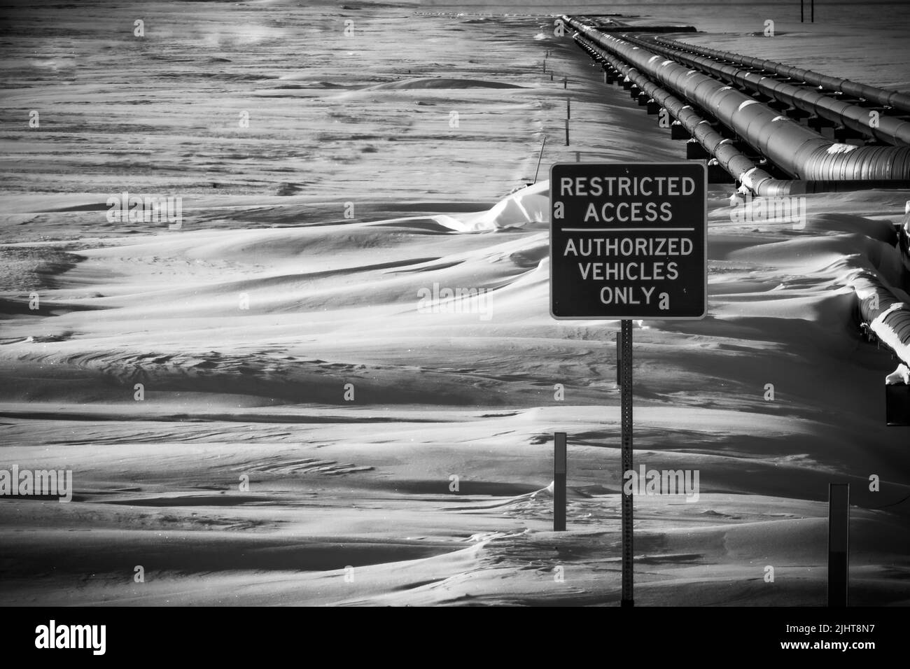 A grayscale of a 'Restricted Access' sign in a snowy field Stock Photo ...