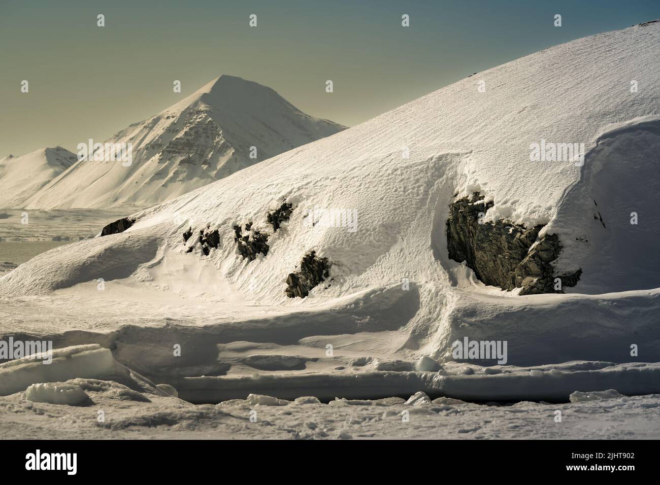 SEVERAL SNOW COVERED MOUNTAINS WITH SMALL SECTIONS OF ROCK EXPOSED NEAR ...