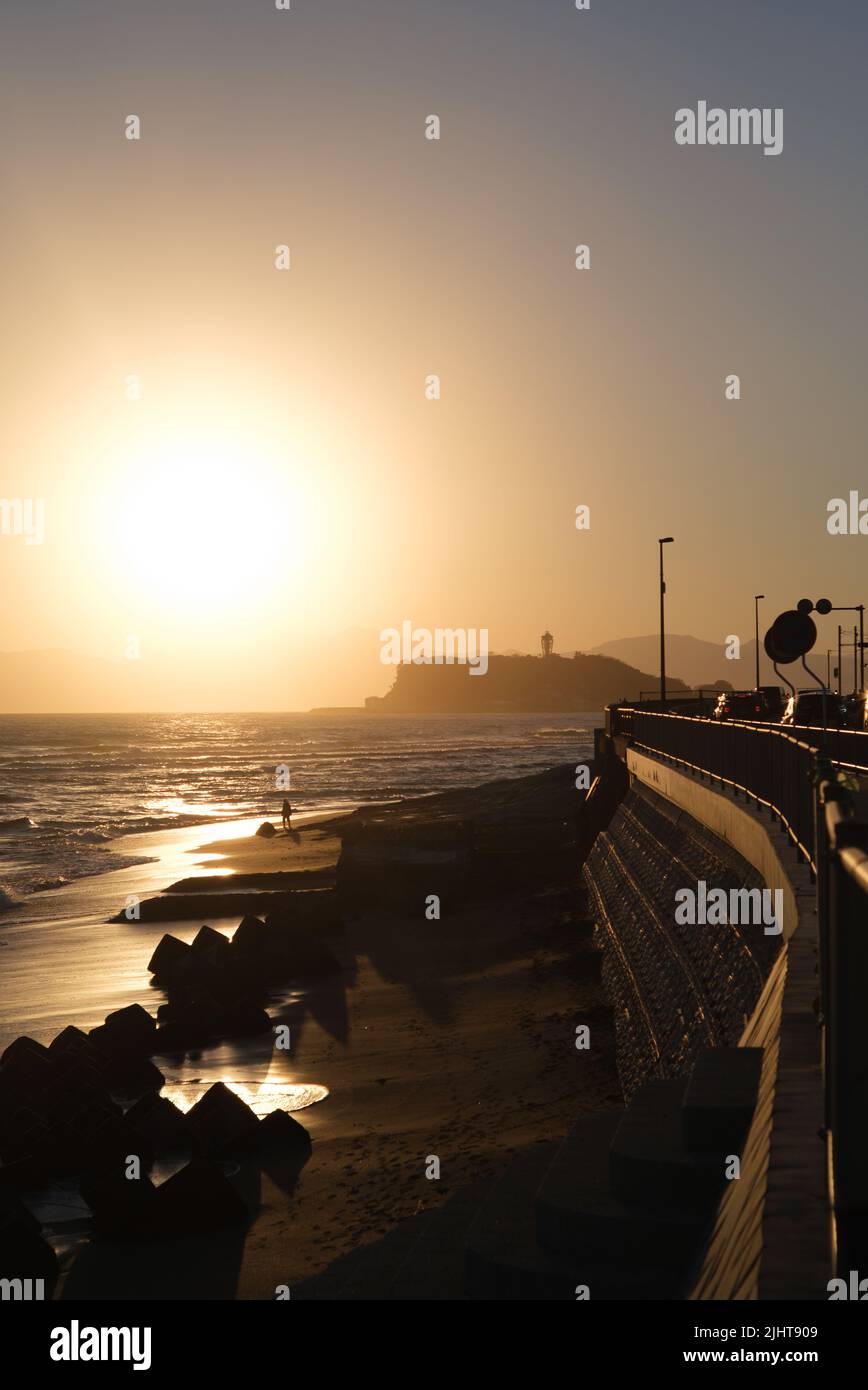 sun is setting behind the Enoshima island on the coast of Kamakura ...
