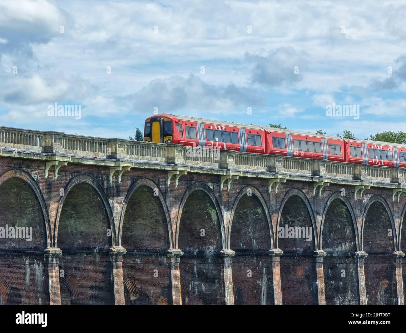 Railway train crossing over the arches of the Ouse Valley Bridge in ...
