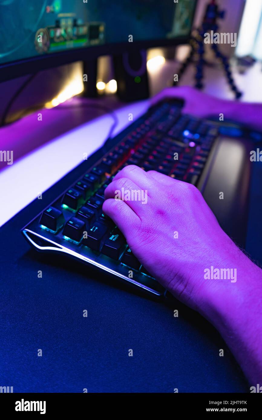A vertical shot of a hand on the keyboard playing a game on the PC in a ...