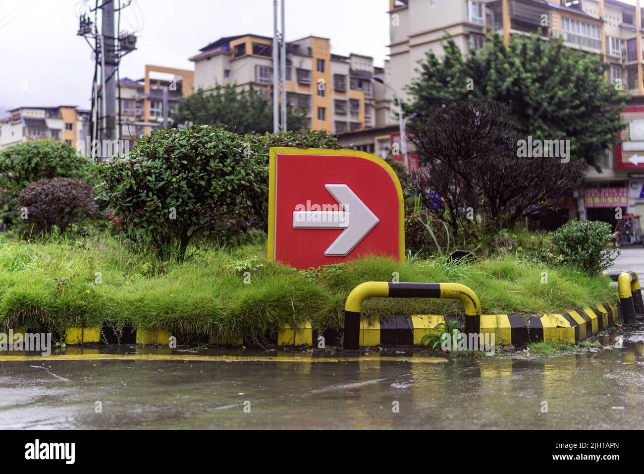 A big red sign with a white arrow showing to the left on the road on a ...