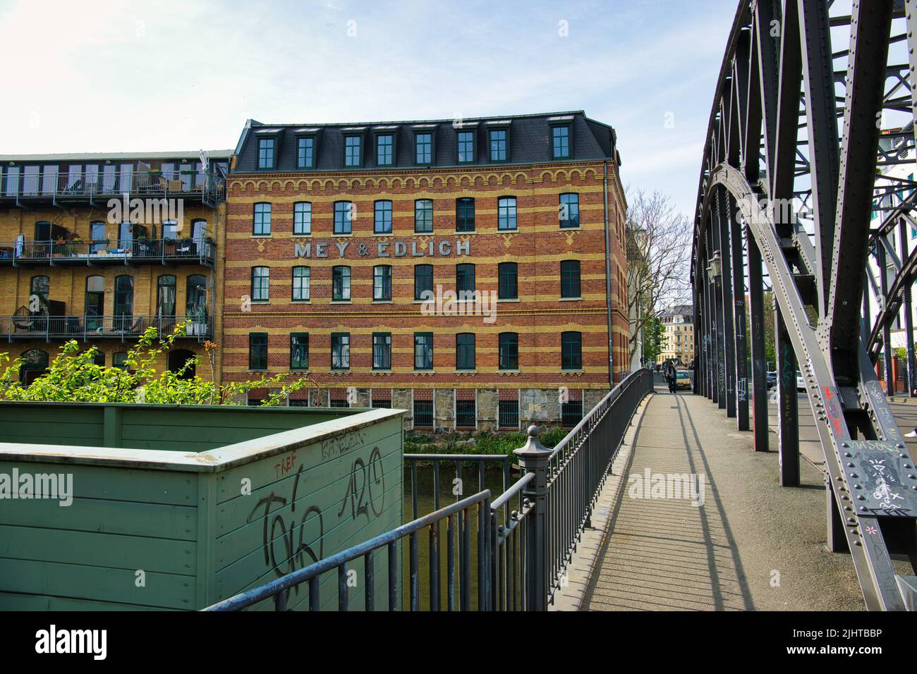 A view of a bridge with metal railings and a vibrant building in the ...