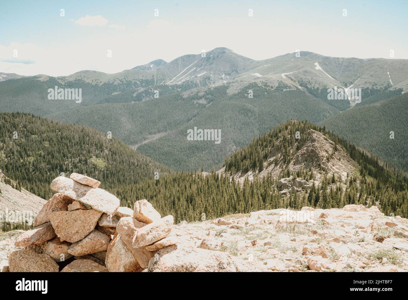 A mesmerizing view from hill to forested mountain range on sunny day in ...