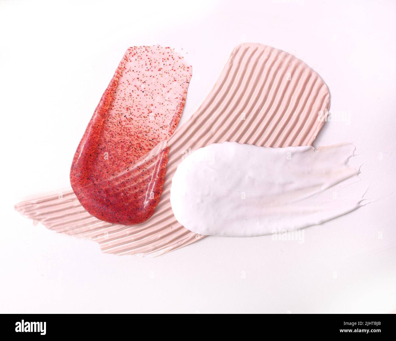 A closeup shot of a makeup smear of a creamy luminous blusher on a pink ...