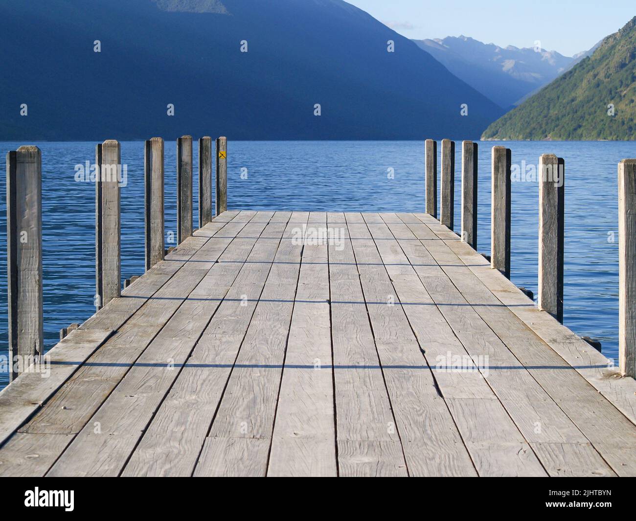 Jetty on Lake Roto-iti projecting into lake with mountain background ...