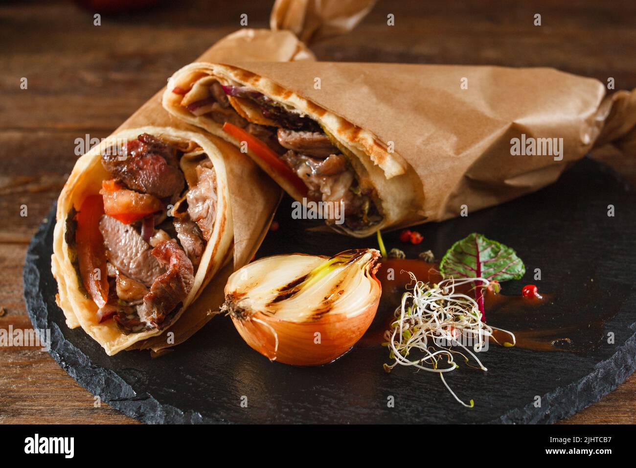 Shawarma rolled in baking paper on plate Stock Photo - Alamy
