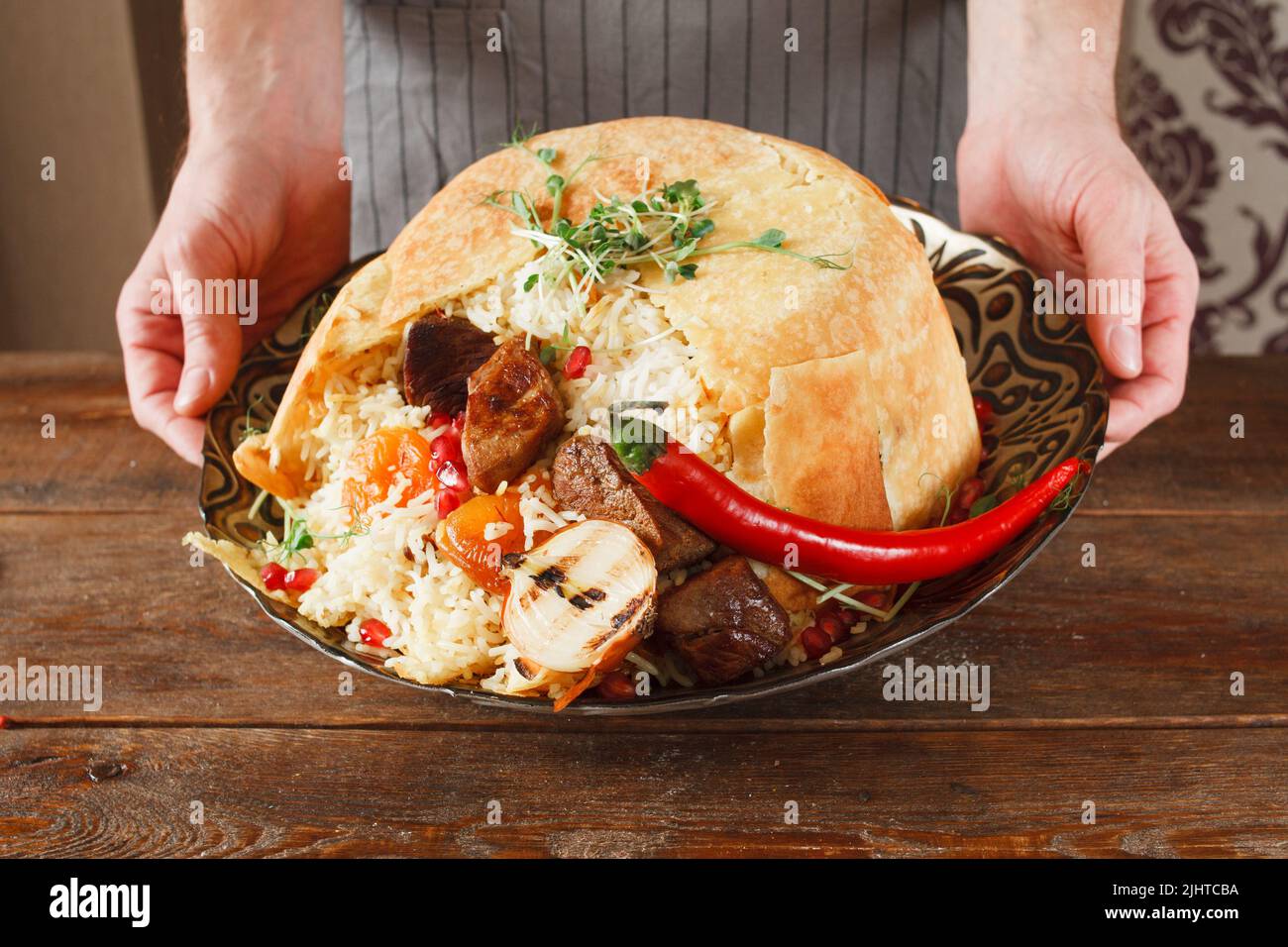 Shah pilaff on big plate holding in hands Stock Photo - Alamy
