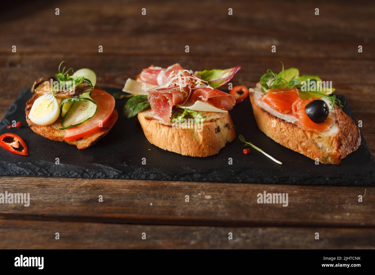 Small canapes laying on black tray Stock Photo - Alamy