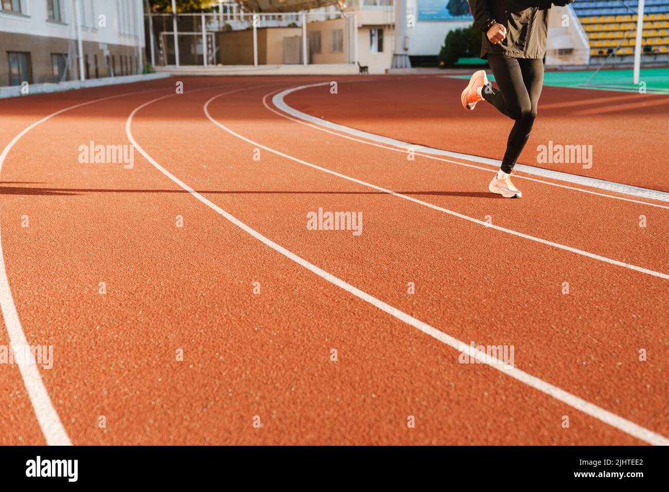 Young white sportsman running while working out on stadium outdoors ...