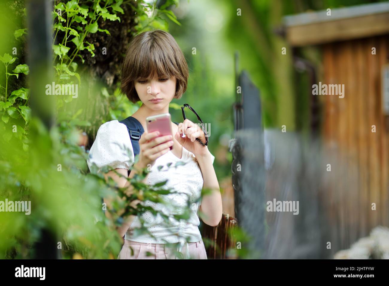 Pretty teenage girl using a smart phone. Cute young girl having fun ...