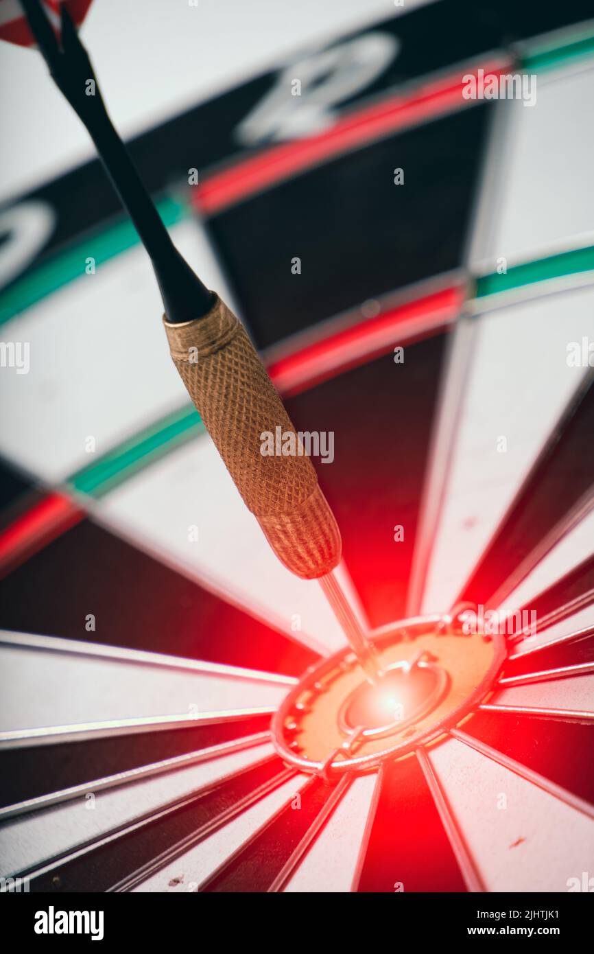 Dart for playing darts hitting exactly center target Stock Photo - Alamy