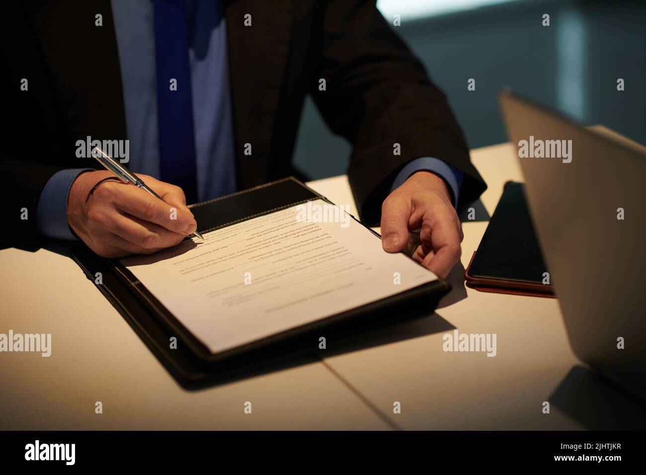 Cropped image of entrepreneur signing important documents in folder at ...