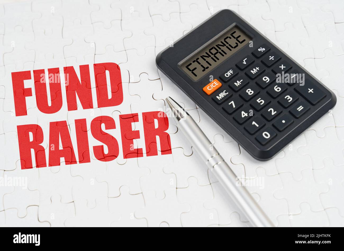 Business concept. On the puzzles lies a calculator and a pen, next to ...