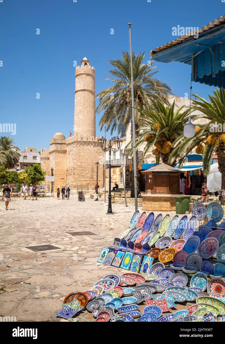 A shop selling traditional ceramics next to the main tower of the Ribat ...
