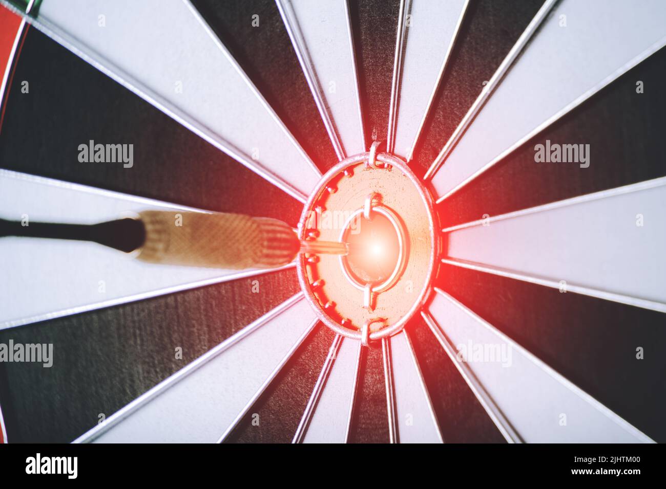 Dart for playing darts hitting exactly center target Stock Photo - Alamy