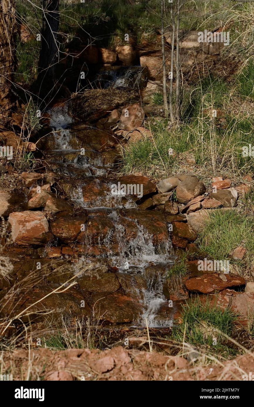 Waterfalls are created by water flowing downhill on a small stream ...