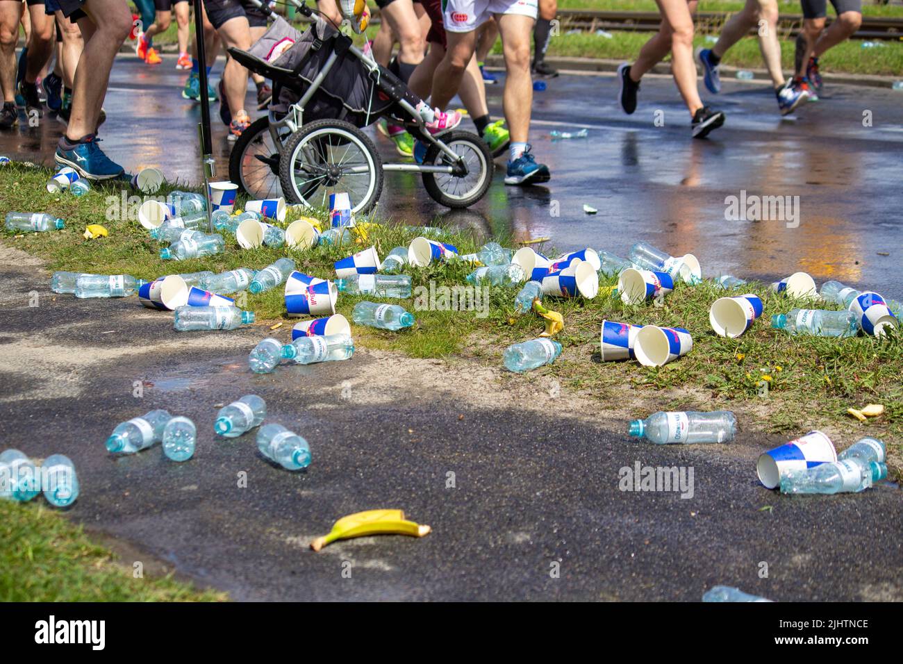 The participants of race run by a water station with bottles and paper ...