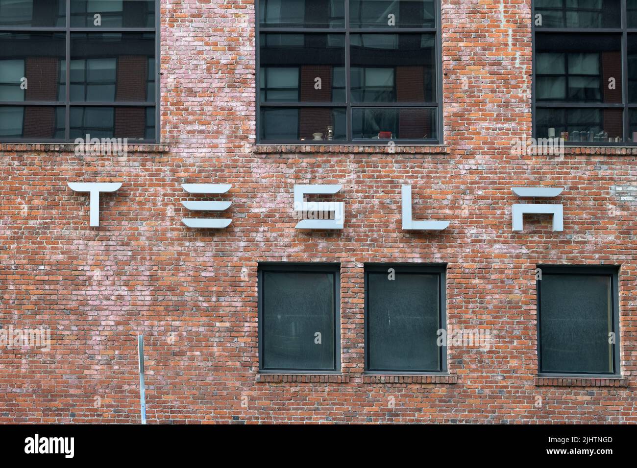 Seattle - July 17, 2022; Tesla company sign on an old brick wall with ...