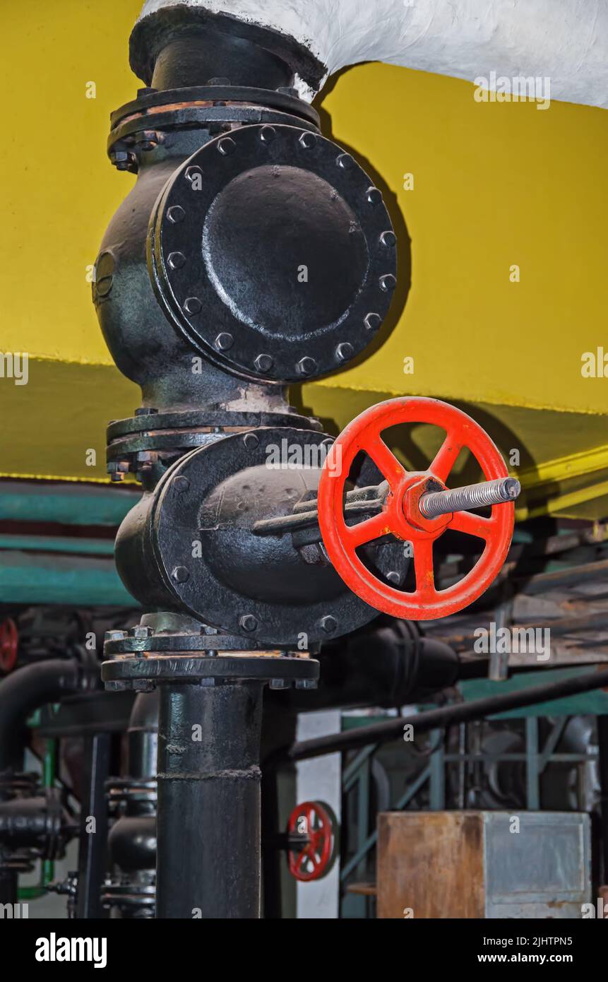 Obsolete plumbing red valve and black big pipe with in abandoned ...