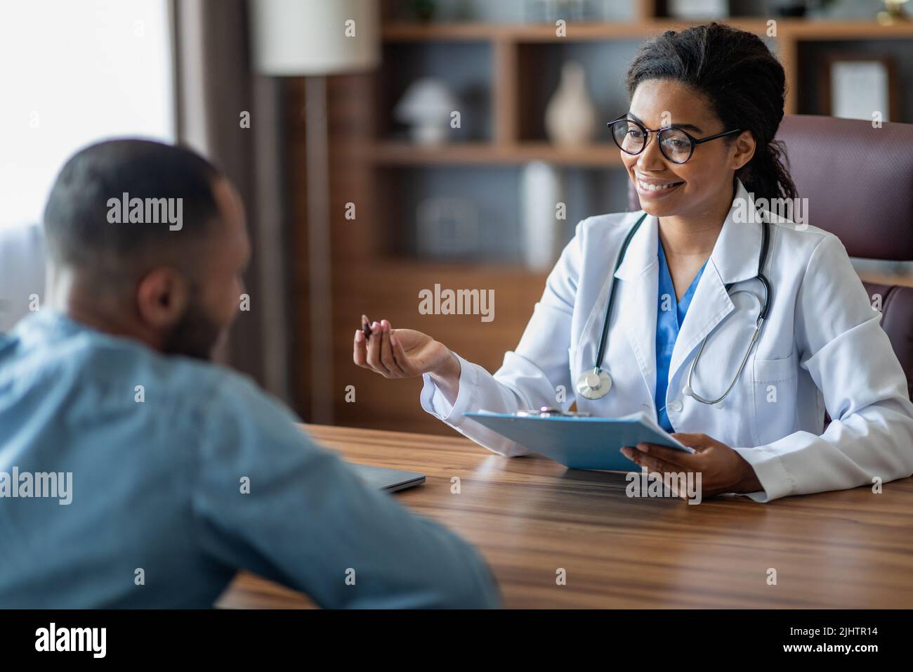 Female doctor taking anamnesis of middle eastern guy patient Stock ...