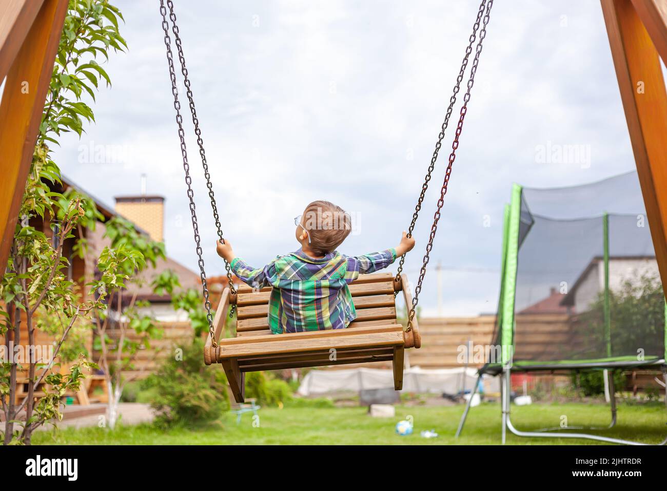 Child swinging on swing in the backyard Stock Photo - Alamy