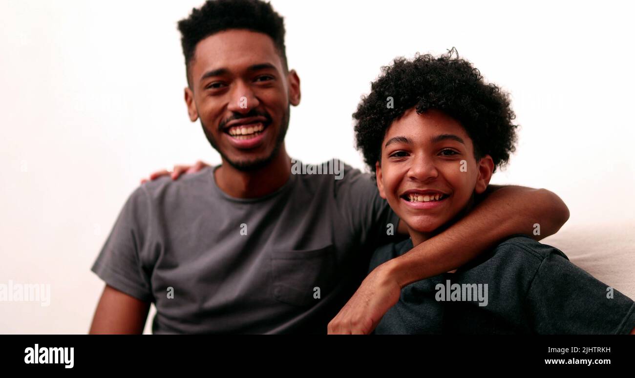 Two brothers together smiling. Black mixed race siblings, older and ...