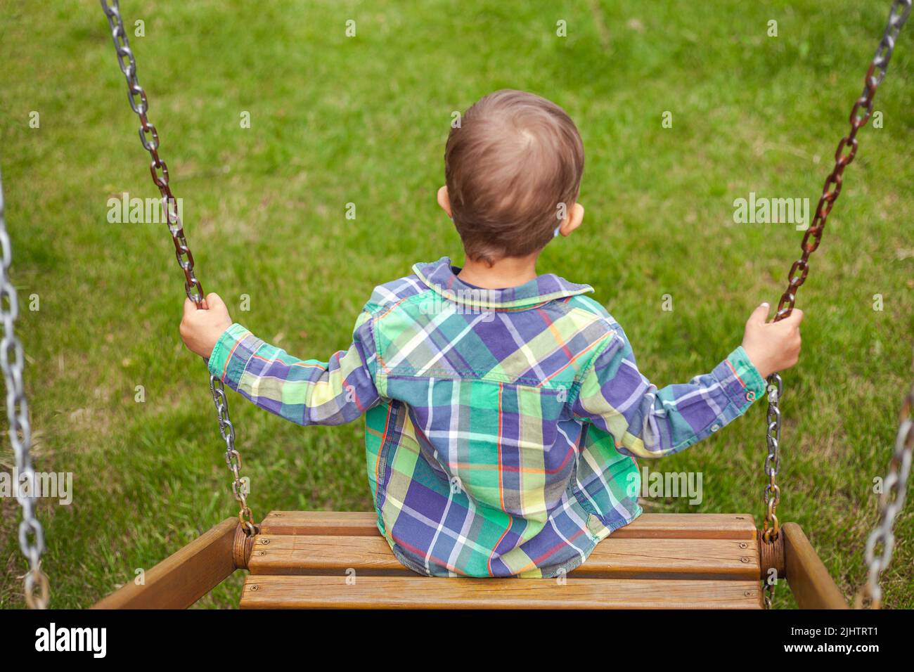 Child swinging on swing in the backyard Stock Photo - Alamy