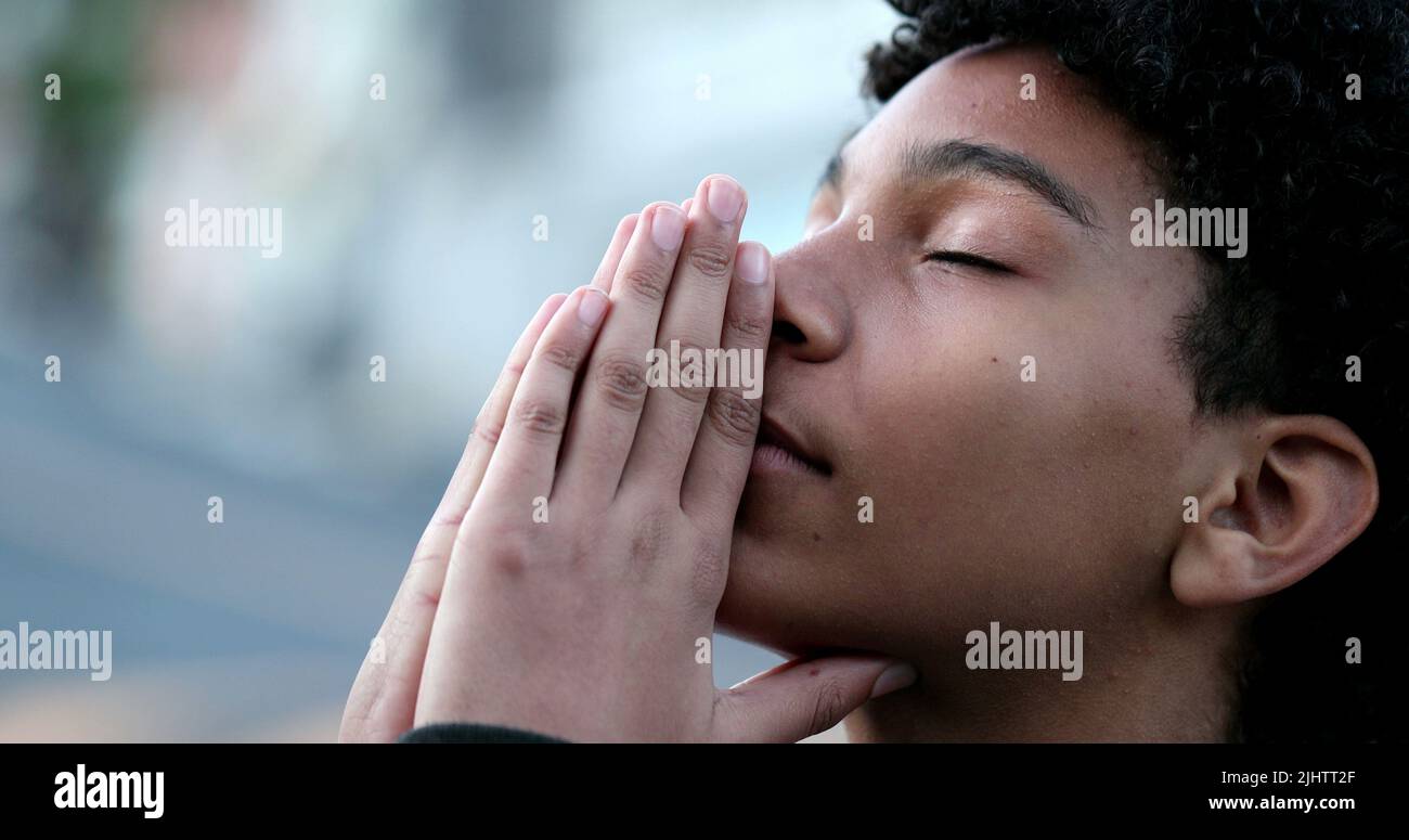 Young boy praying to God. Religious Mixed race child looking at sky ...