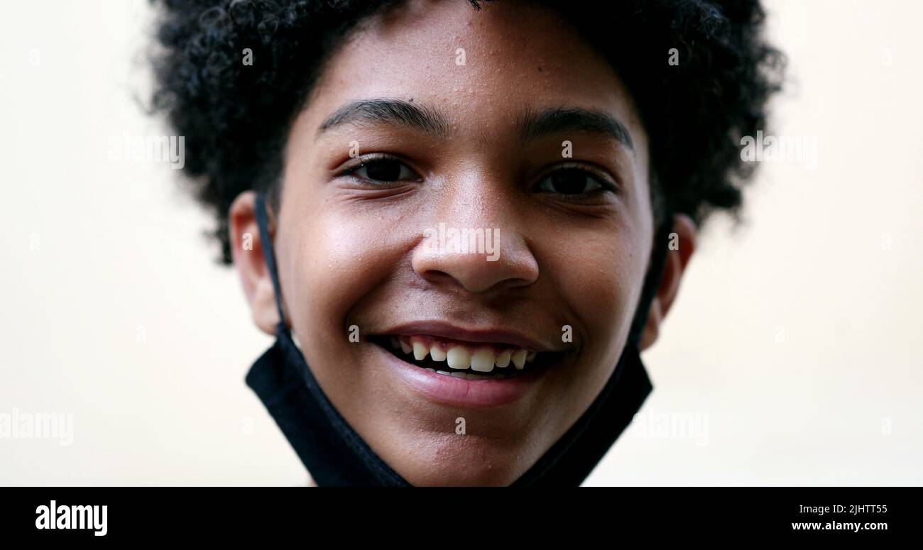 Young boy taking off covid face mask. Mixed race kid removes covid mask ...