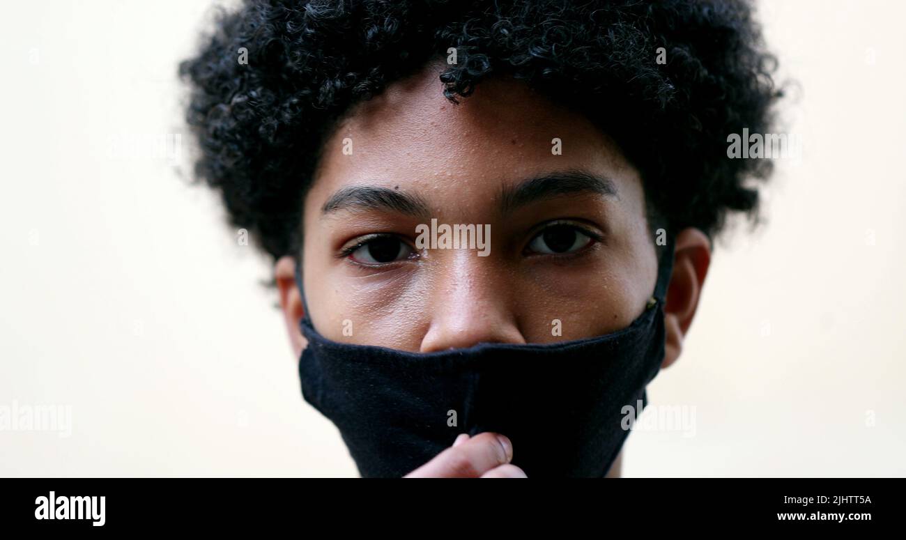 Young boy taking off covid face mask. Mixed race kid removes covid mask ...