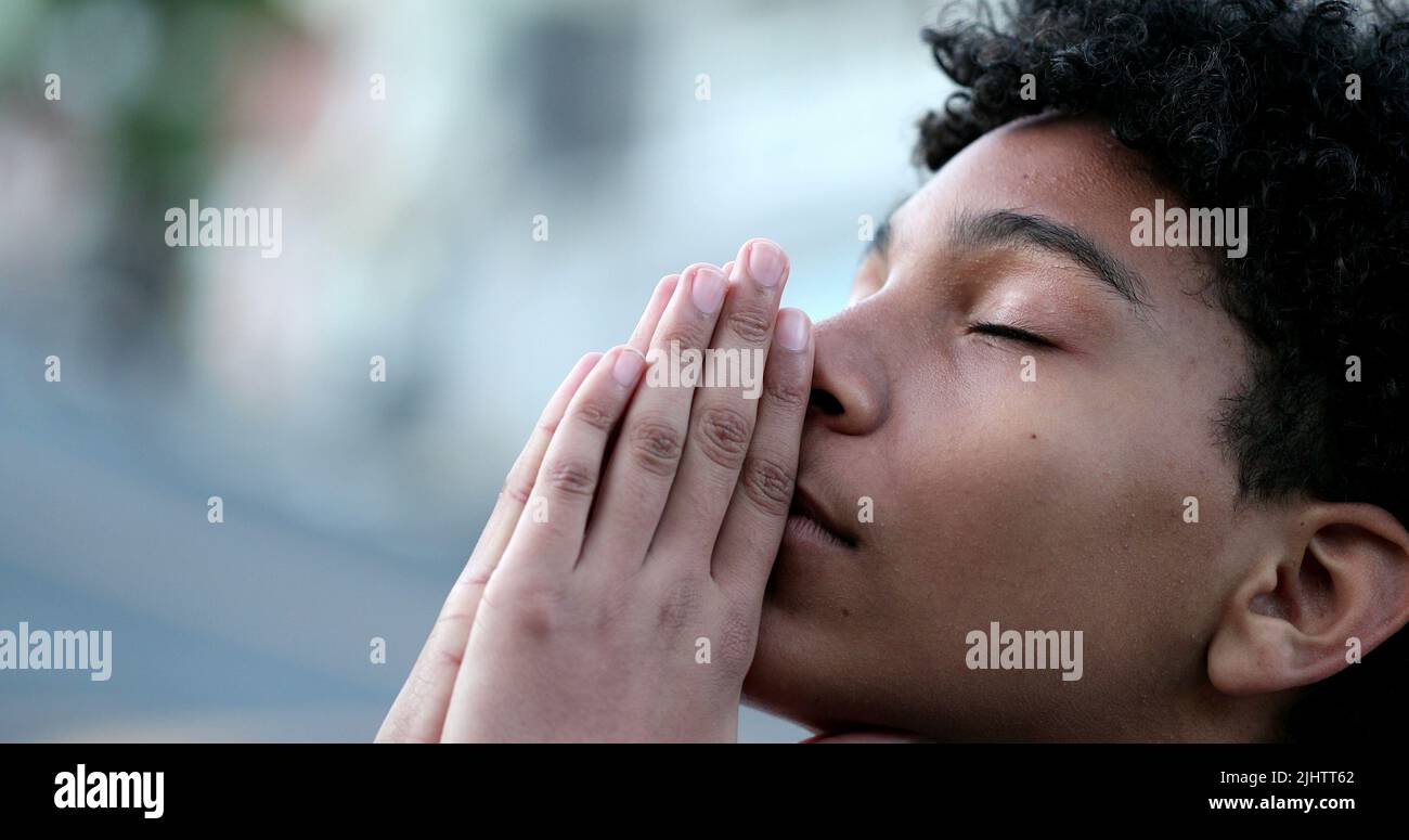Young boy praying to God. Religious Mixed race child looking at sky ...