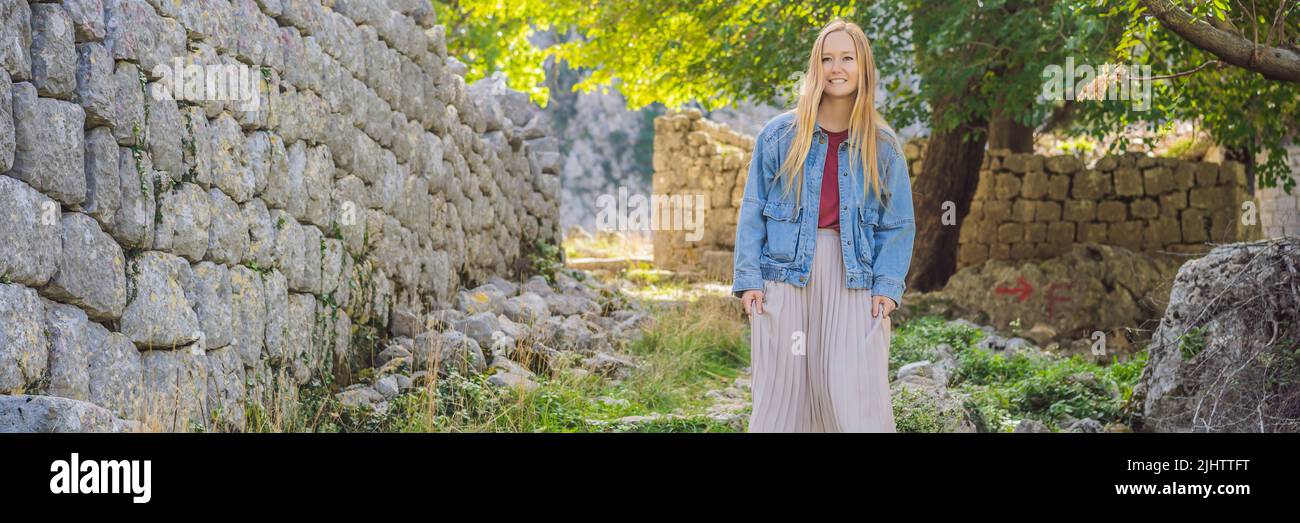 BANNER, LONG FORMAT Woman tourist enjoys the view of Kotor. Montenegro ...