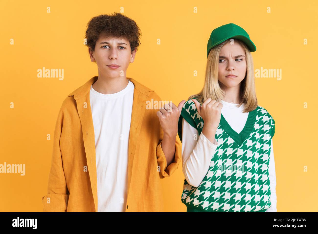 White girl and boy frowning while pointing fingers at each other ...