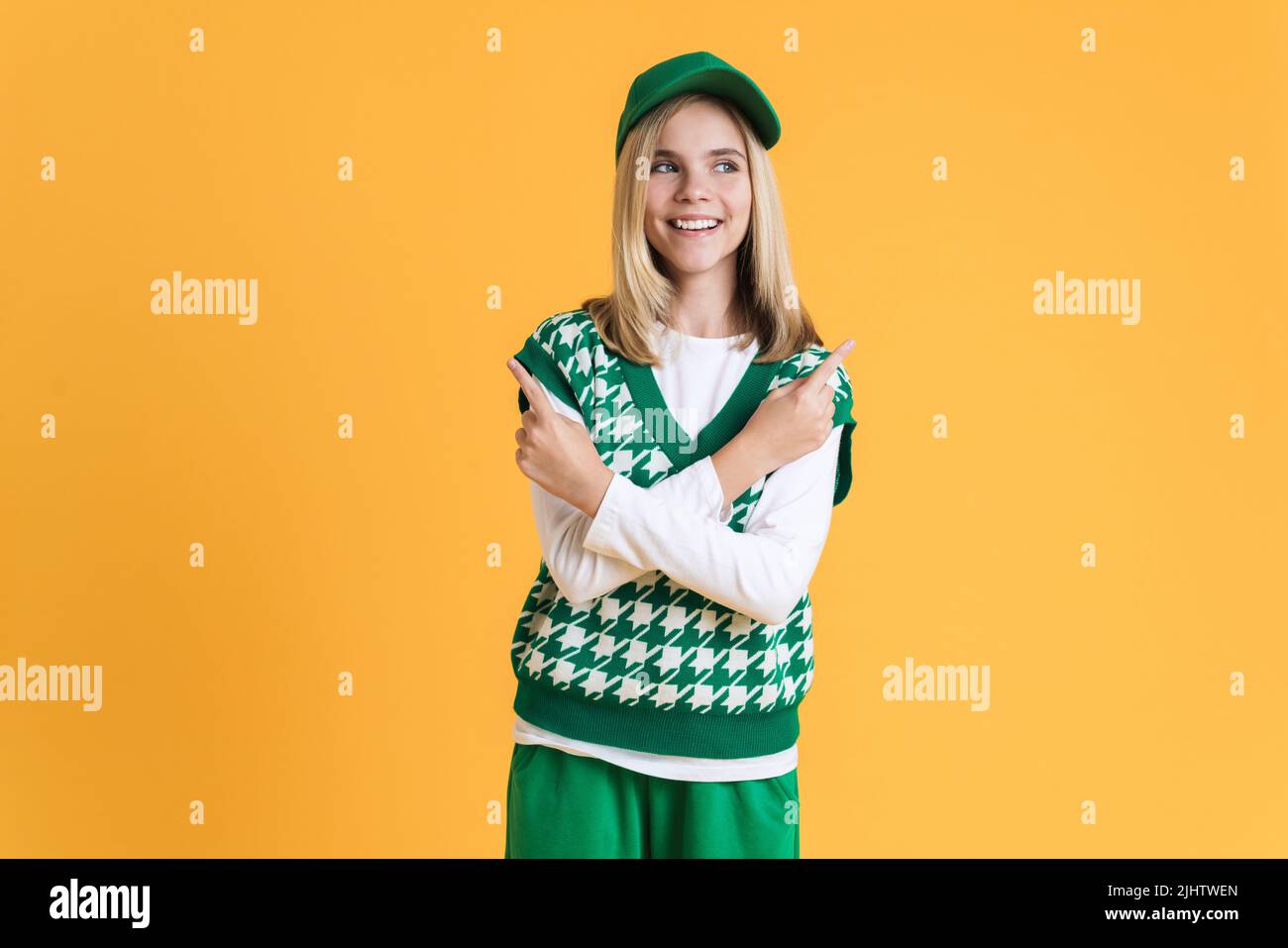 White girl wearing vest pointing fingers in different directions ...