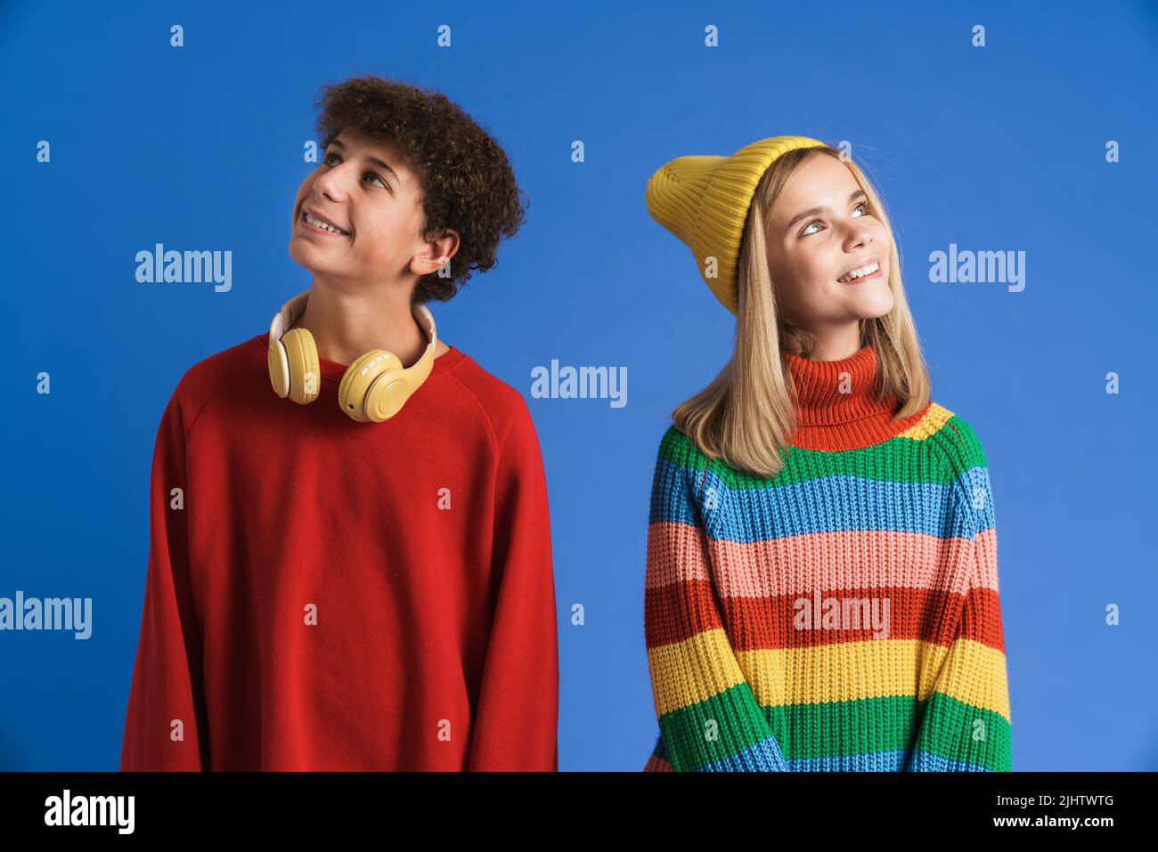 White two teenagers smiling while looking to opposite sides isolated ...