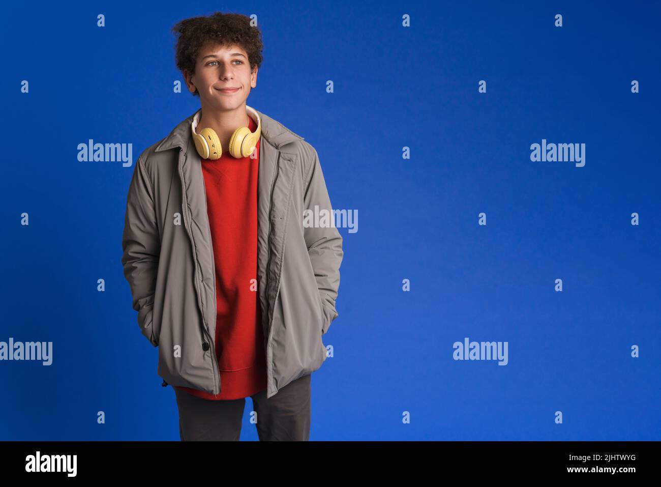 White boy wearing jacket smiling while posing with headphones isolated ...