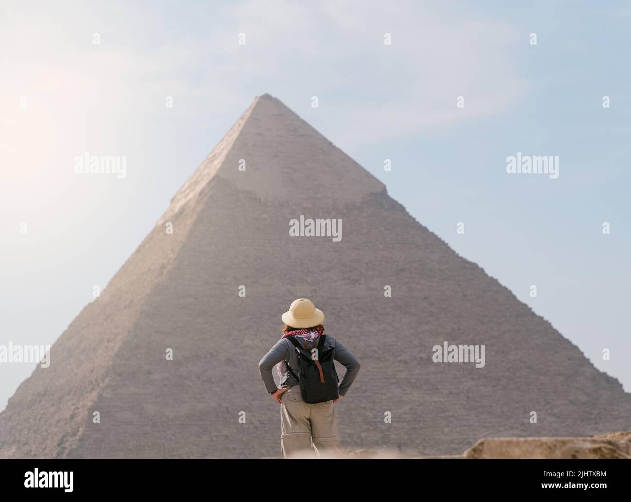 back view of tourist woman standing in front of a pyramid. Egypt, Cairo ...